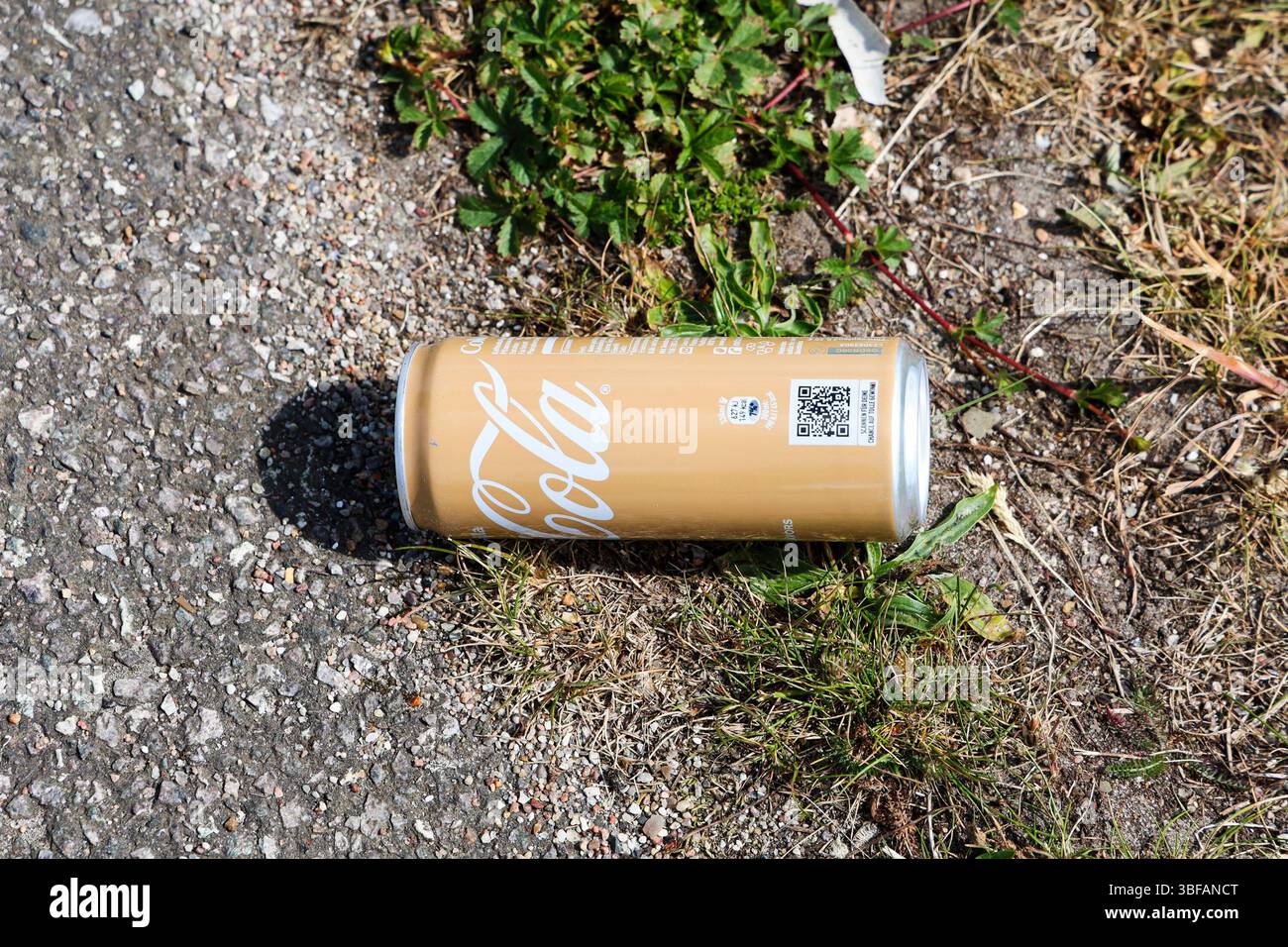 Kiel, Germany - 28. May 2025: Discarded Coca-Cola can lying on roadside ...