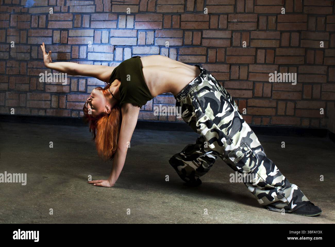 Hip hop girl dancing in modern style over urban blue brick wall Stock ...