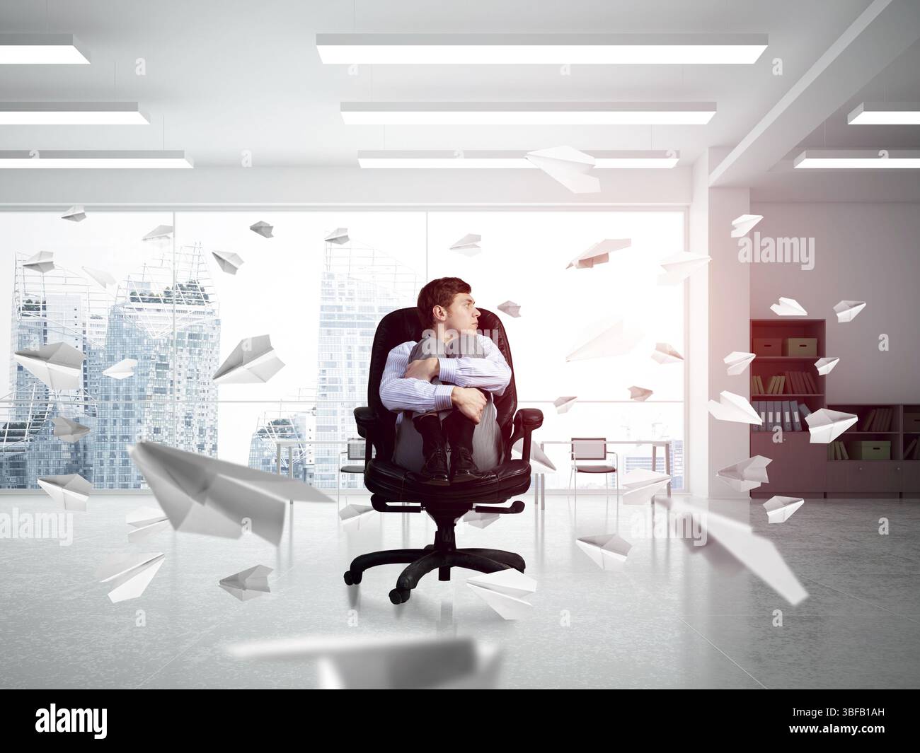 Scared businessman sitting on a chair with his hands clasped his knees ...