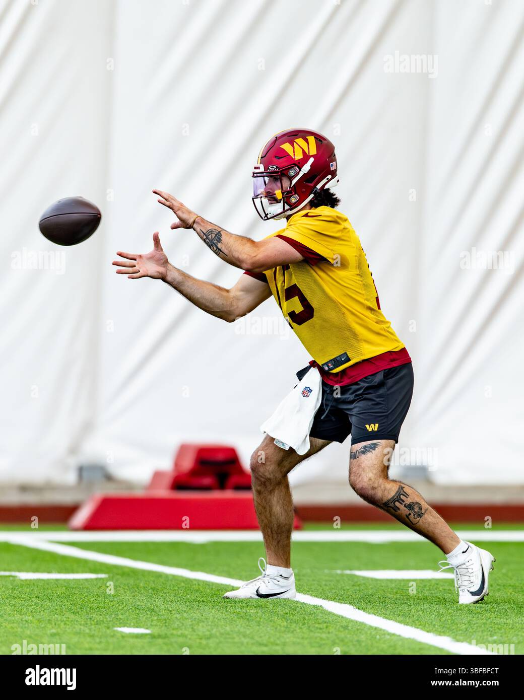 Washington Commanders quarterback Sam Hartman (15) running drills ...