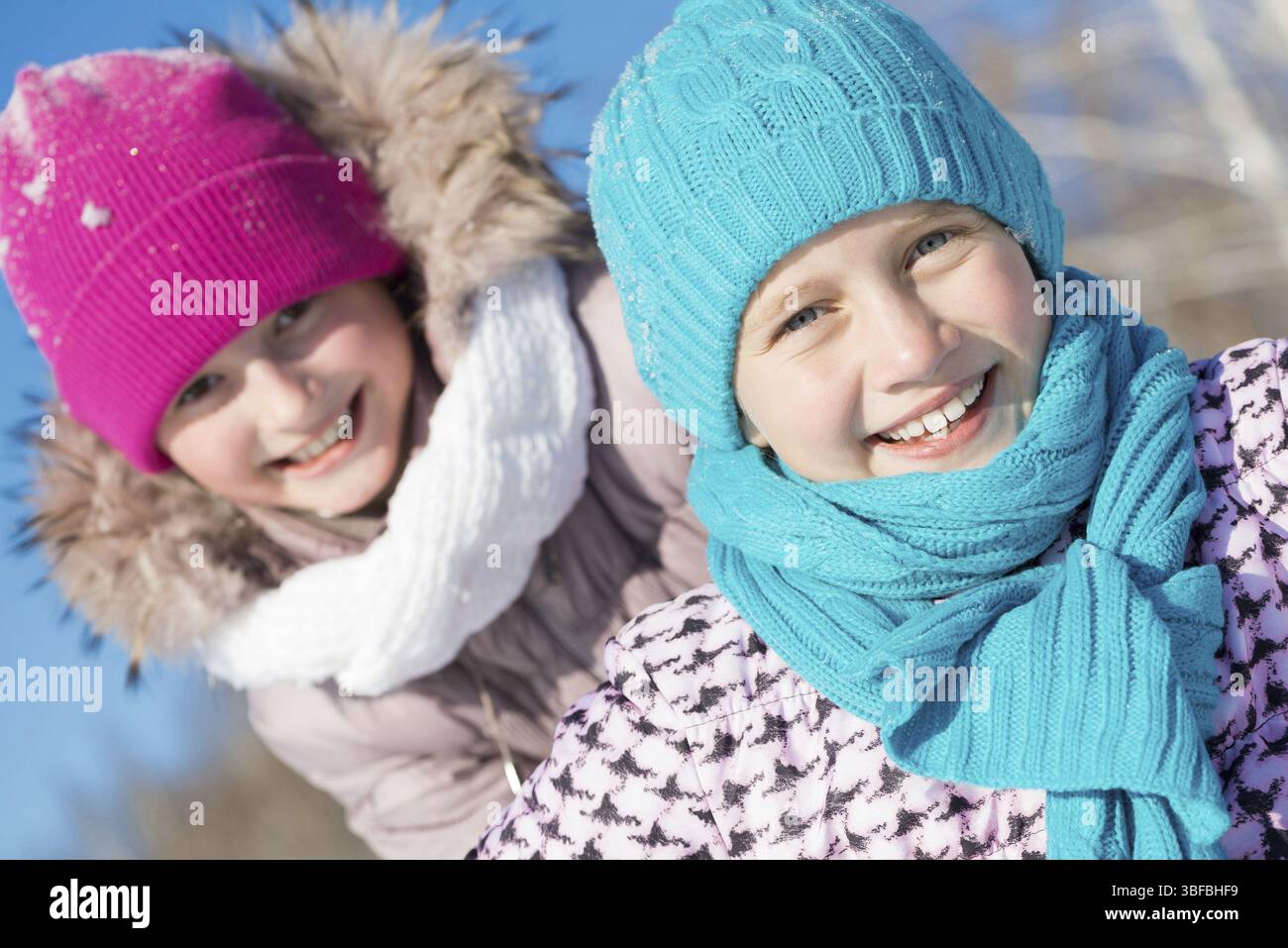 Two cute girls riding sled and having fun Stock Photo - Alamy