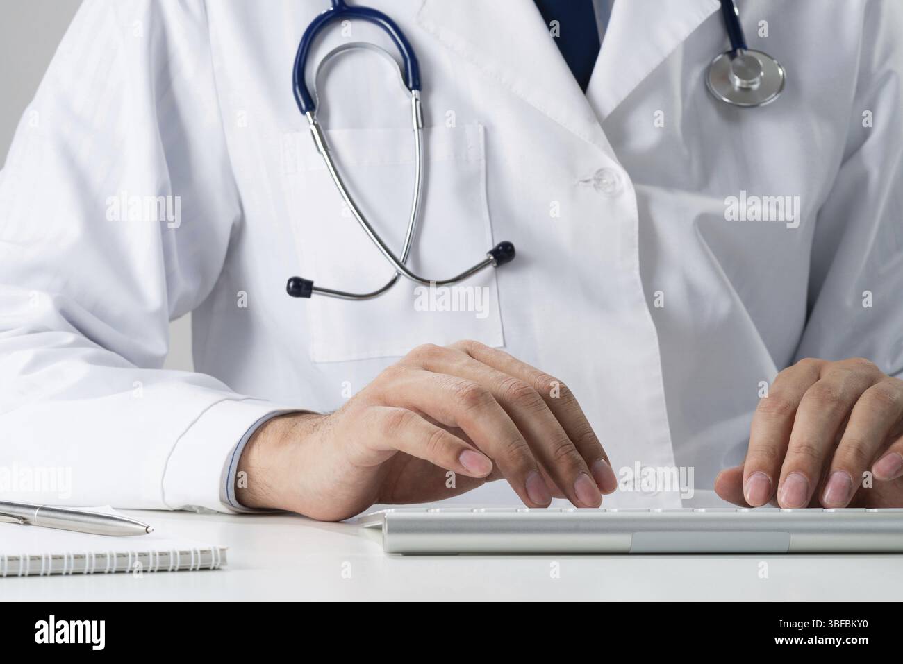 Male therapist typing at wireless computer keyboard. Physician in ...