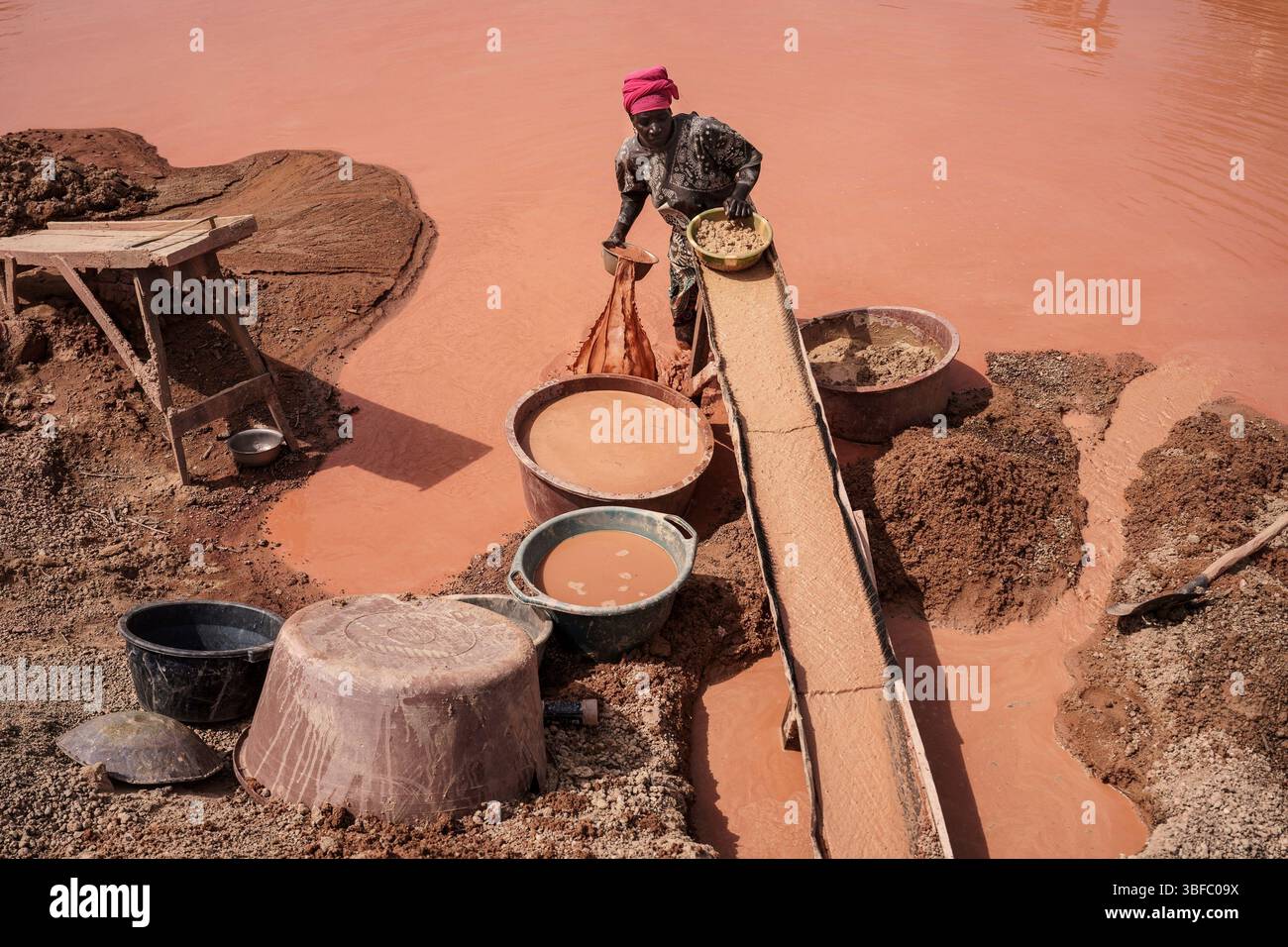 A woman processes gold at a mining site in the Kedougou region of ...