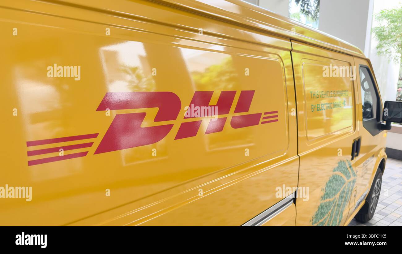 Penang, Malaysia – April 16, 2025: A DHL delivery van is parked next to ...