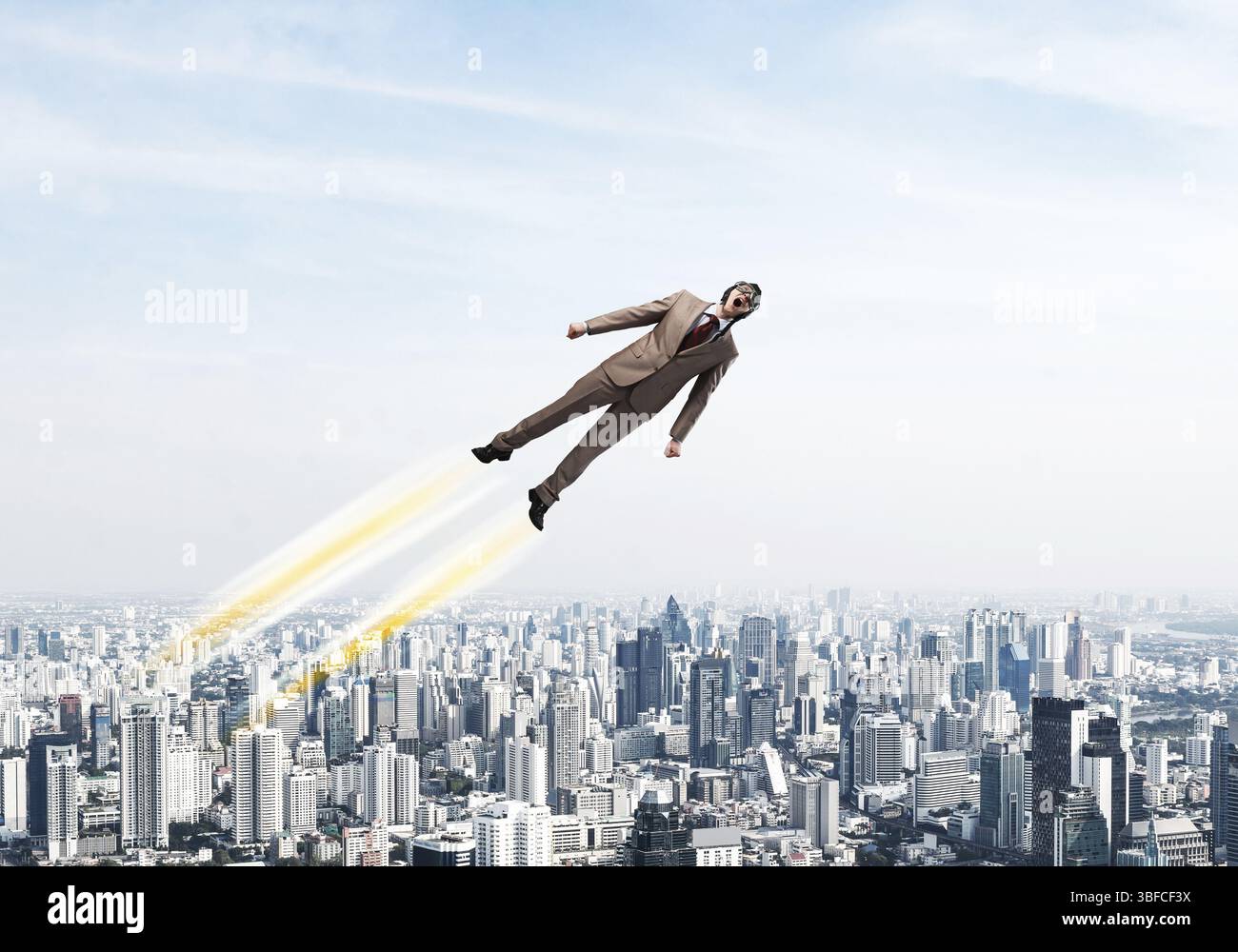 Businessman in suit and aviator hat flying in blue sky as superhero ...