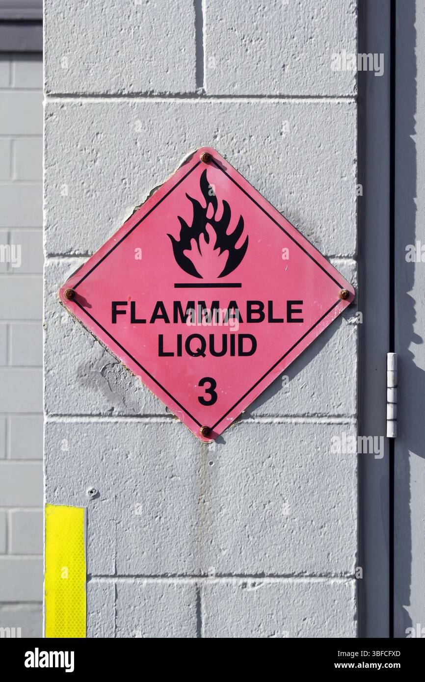 Red diamond-shaped Flammable Liquid warning sign attached to a white ...