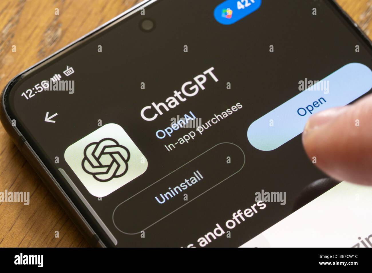 Man about to open ChatGPT on his smartphone, UK. Concept: power demand ...