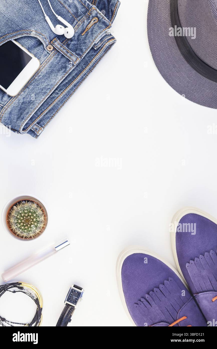 Flat lay of suede shoes, blue jeans, grey hat, cactus and smartphone ...