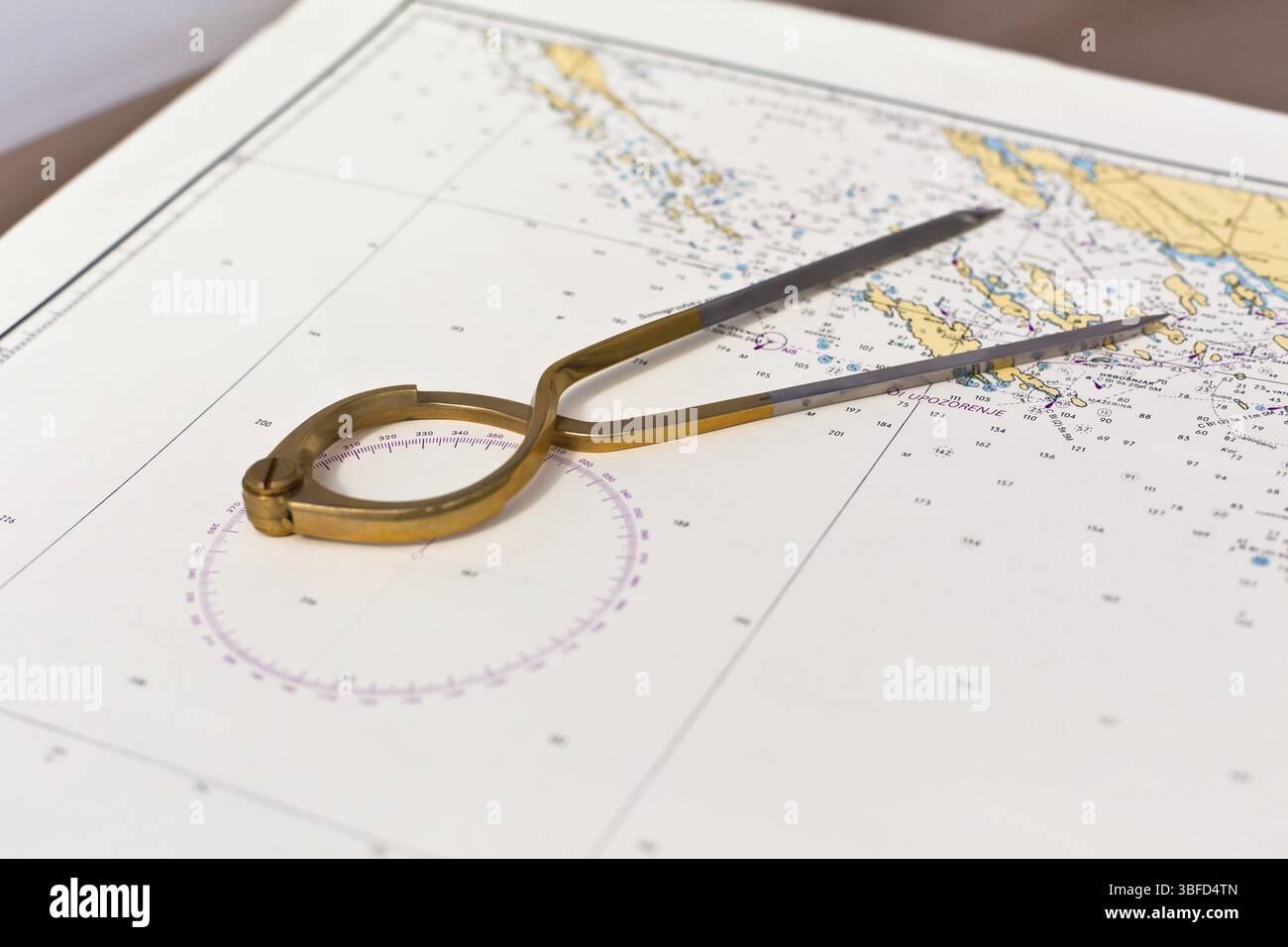 Pair of compasses for navigation on a sea map with low depth of field ...
