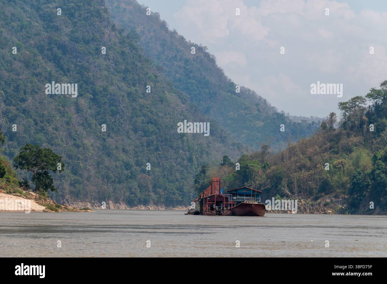 A large floating gold gravel conveyor/ extractor being towed up the ...