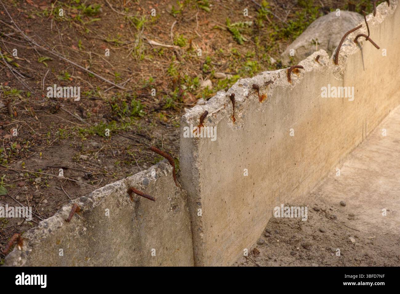 A broken concrete wall with visible rebar outdoors Stock Photo - Alamy