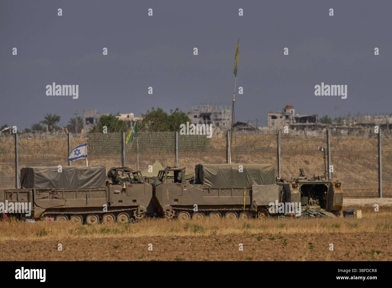 Israeli army vehicles are seen at a staging area near the border with ...