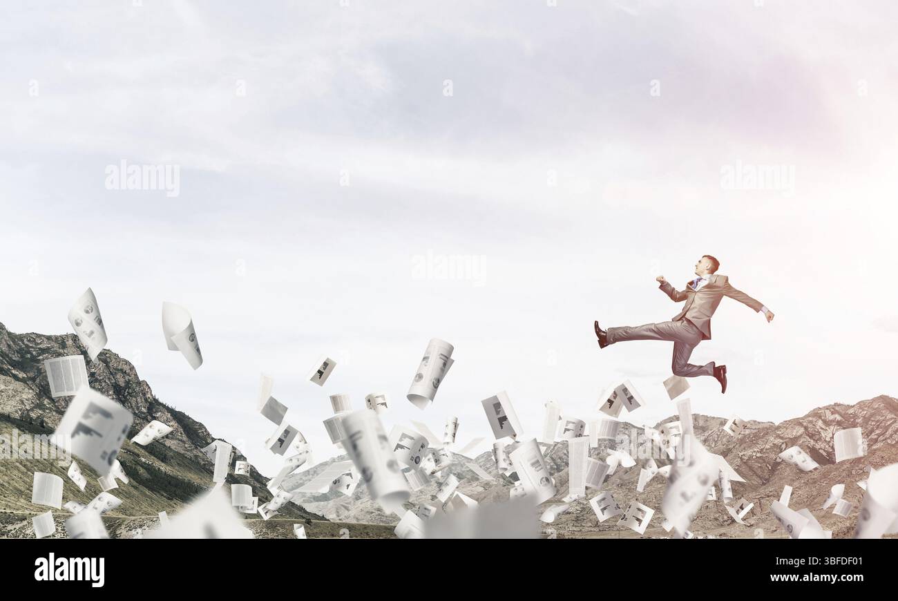 Businessman in suit running in the air among flying papers as symbol of ...