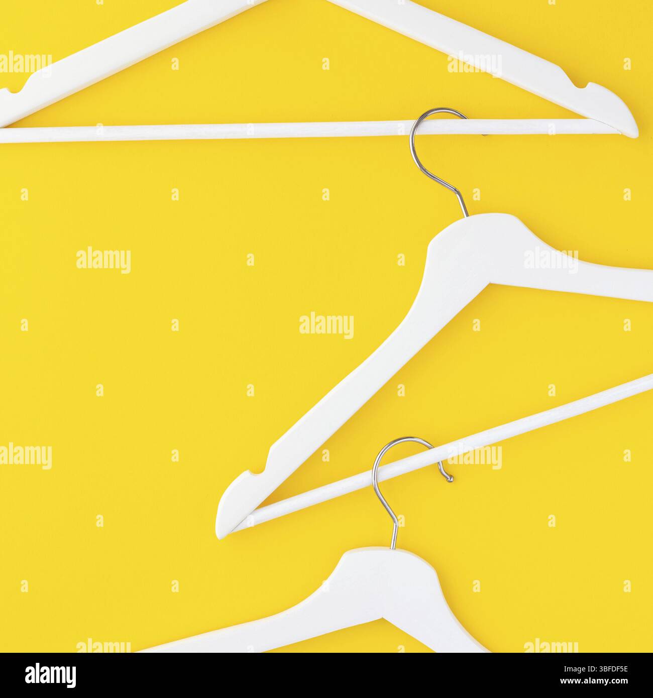 Creative top view flat lay white wooden hangers isolated bold yellow ...