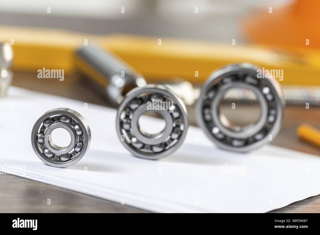 Three various ball bearings lying on paper sheet. Heavy industry ...