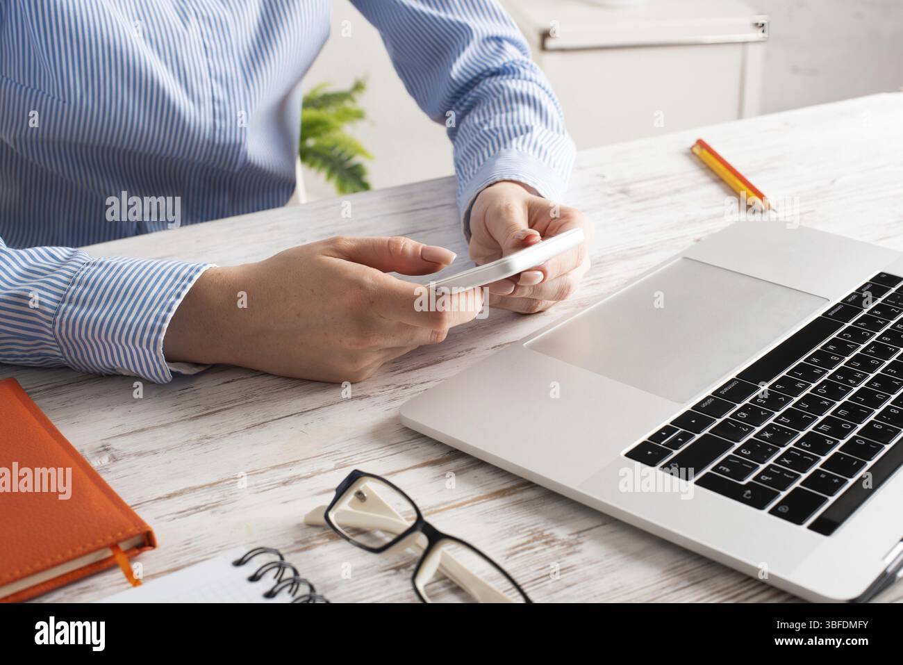 Business lady sitting at desk and using mobile phone. Corporate office ...