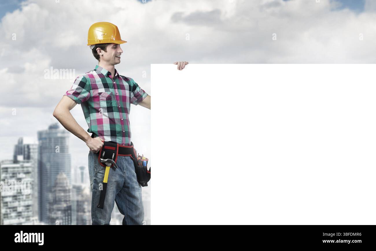 Young builder man with white blank banner. Place your text Stock Photo ...