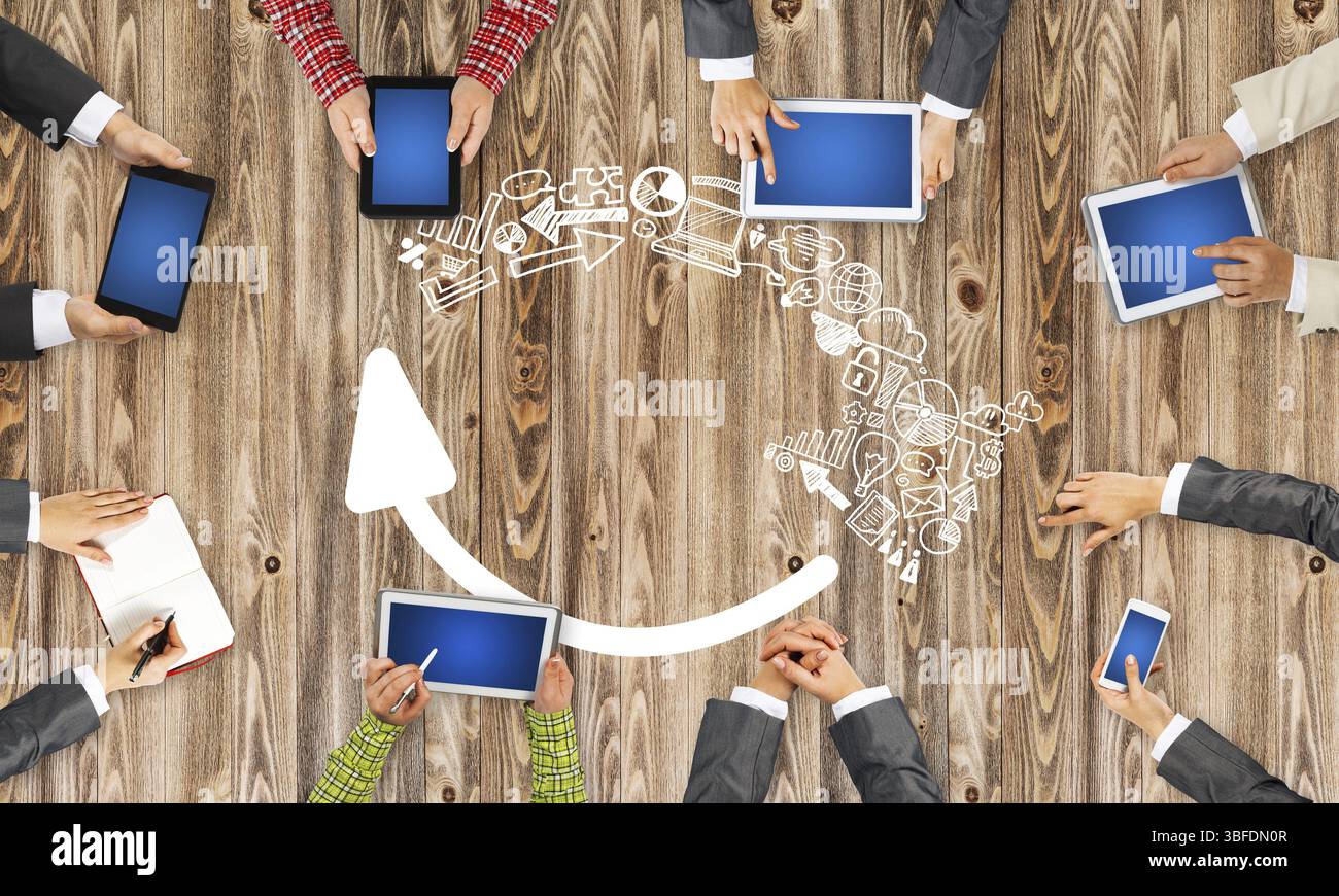 Group of people with devices in hands working together as symbol of ...