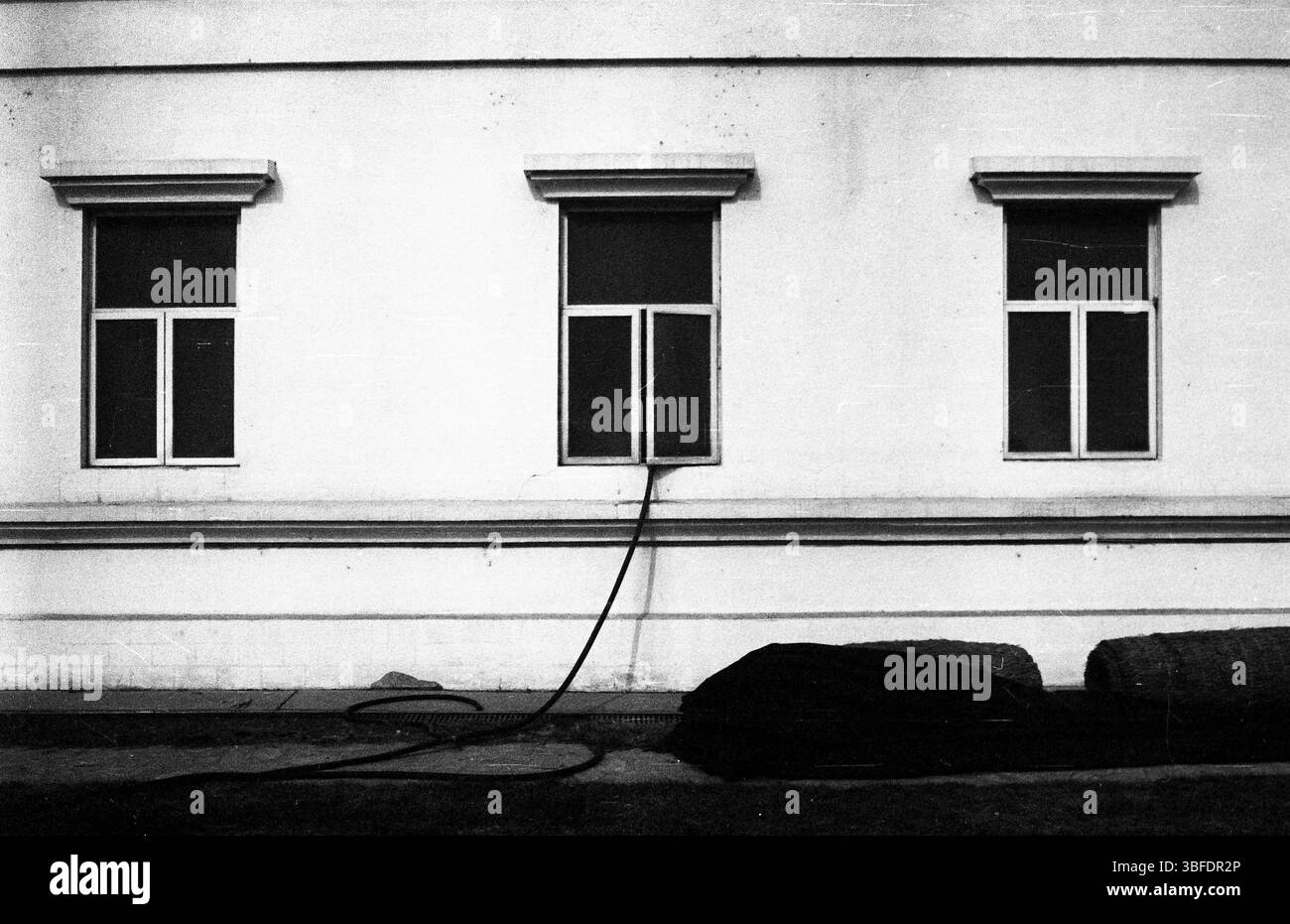 Three Windows with Hose on White Facade, Minimalist Urban Detail Stock ...