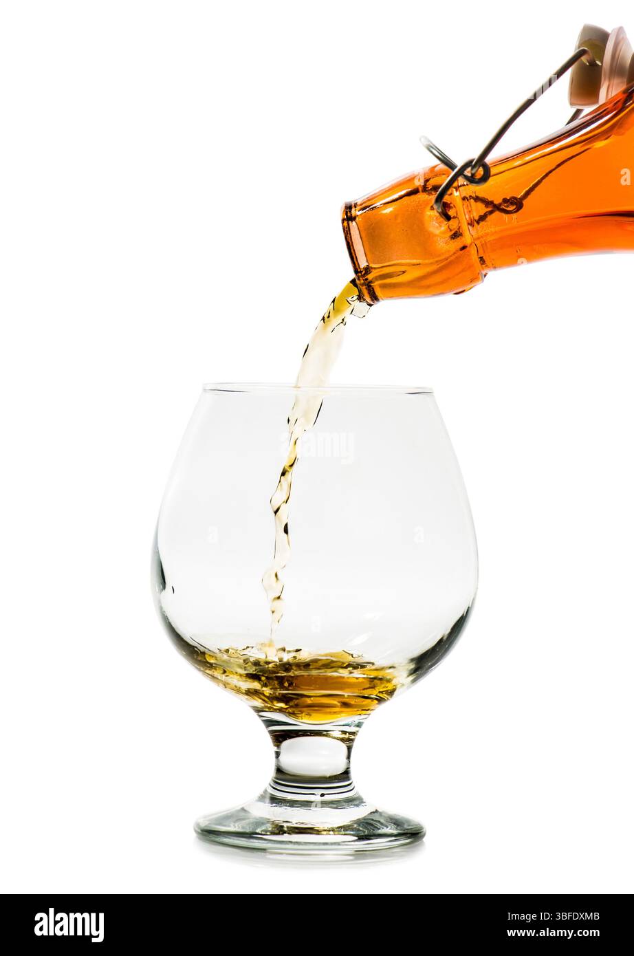 Pouring a glass of brandy from a bottle isolated on a white background ...