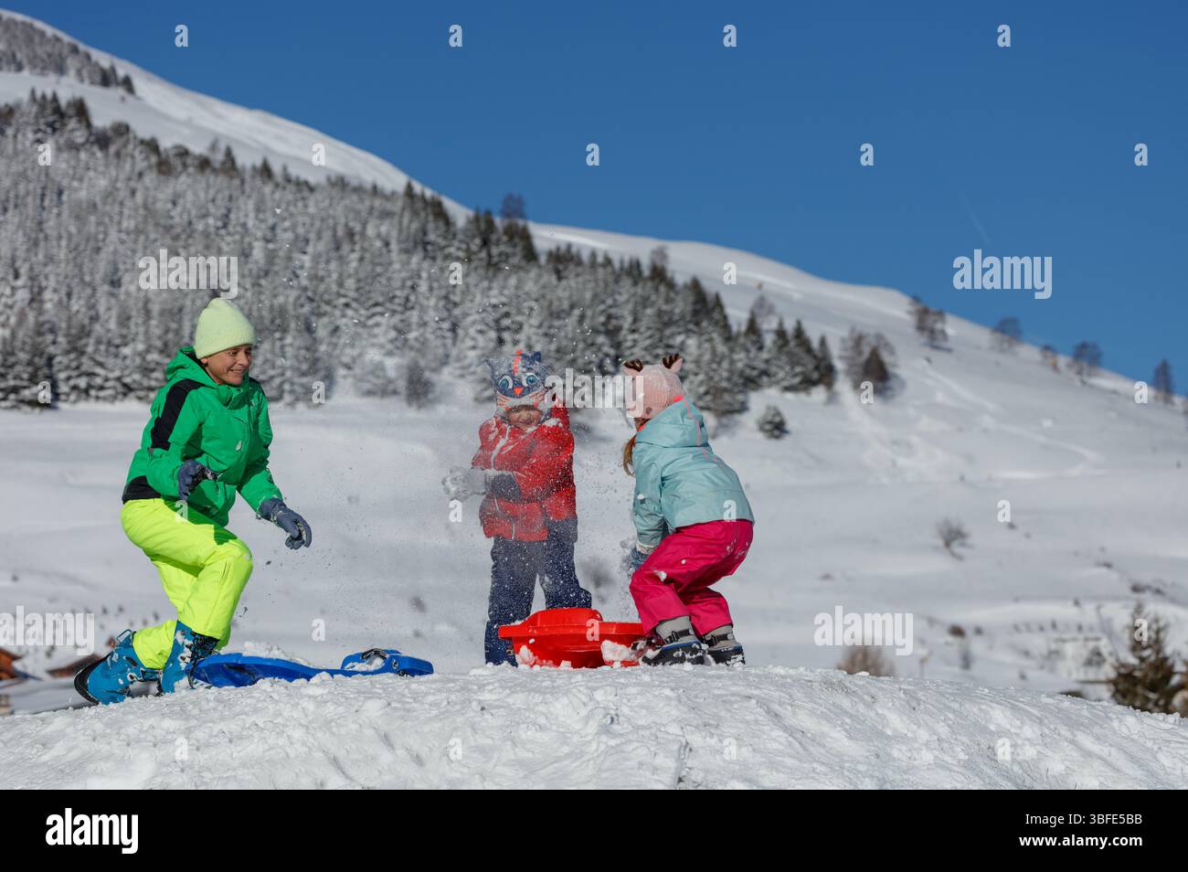 Happy girl and boys have fun snowball fighting on mountain slope Stock ...