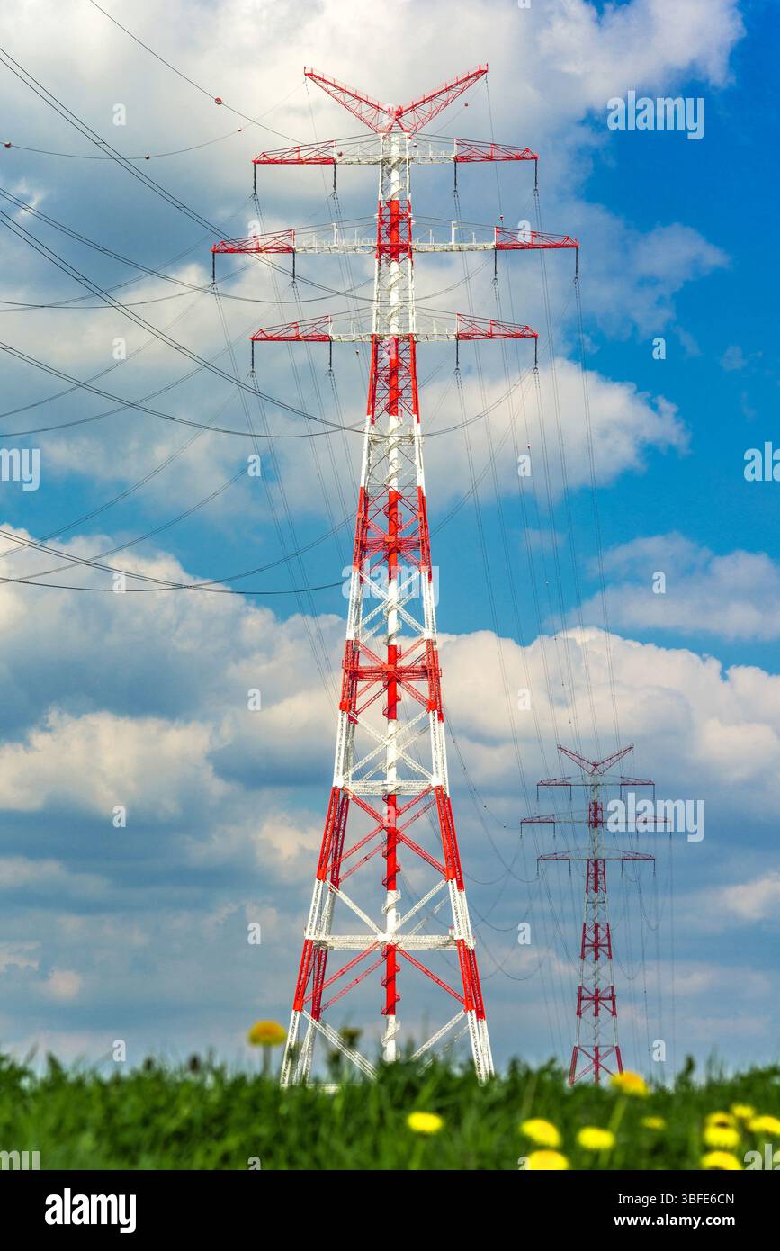 Red and white high-voltage mast of a power line Stock Photo - Alamy