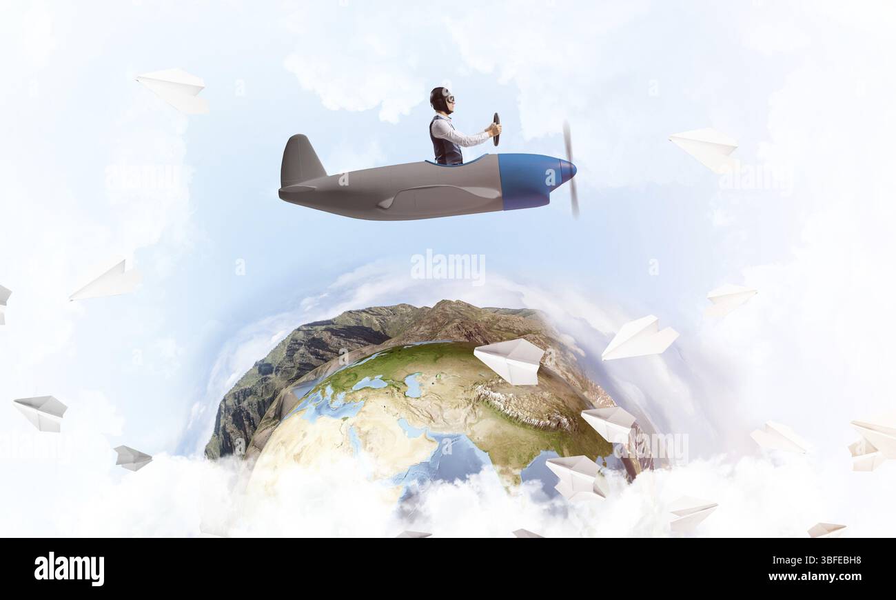 Pilot in leather helmet driving propeller plane on background of blue ...