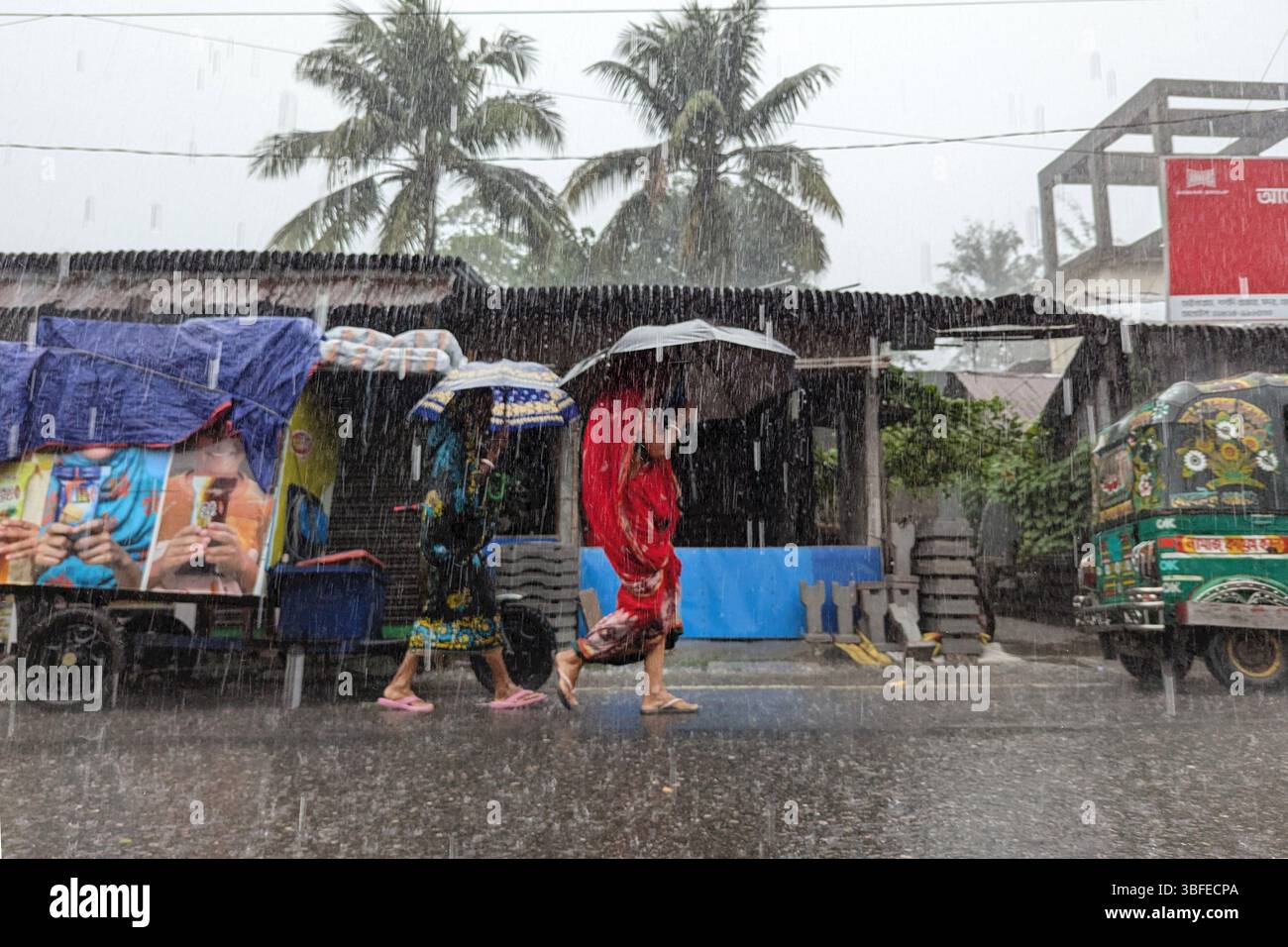 Commuters rush through heavy monsoon rain in Feni, Bangladesh, on June ...