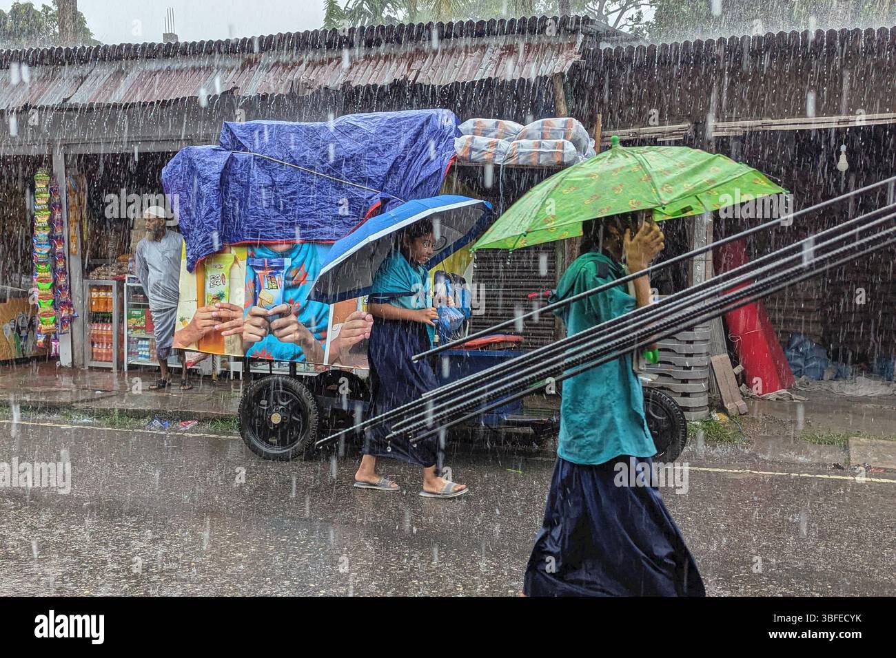School students rush through heavy monsoon rain in Feni, Bangladesh, on ...