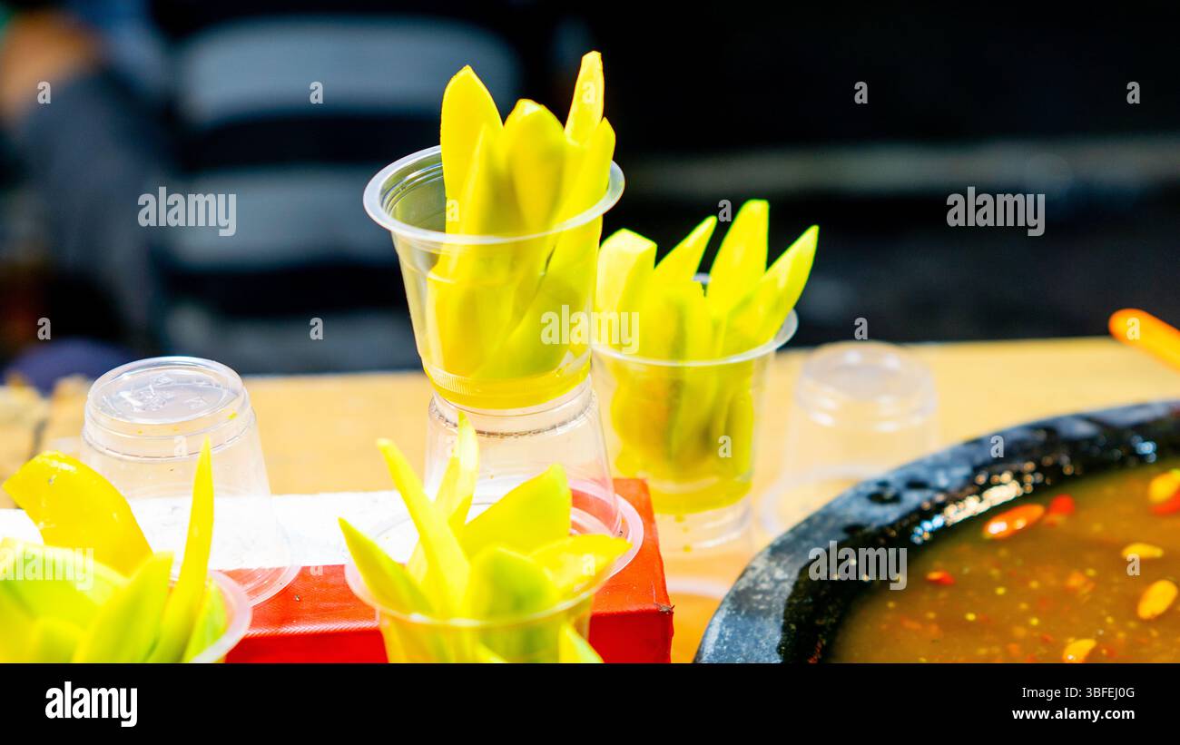 Pickled mango in plastic cups. A typical Indonesian snack made from ...