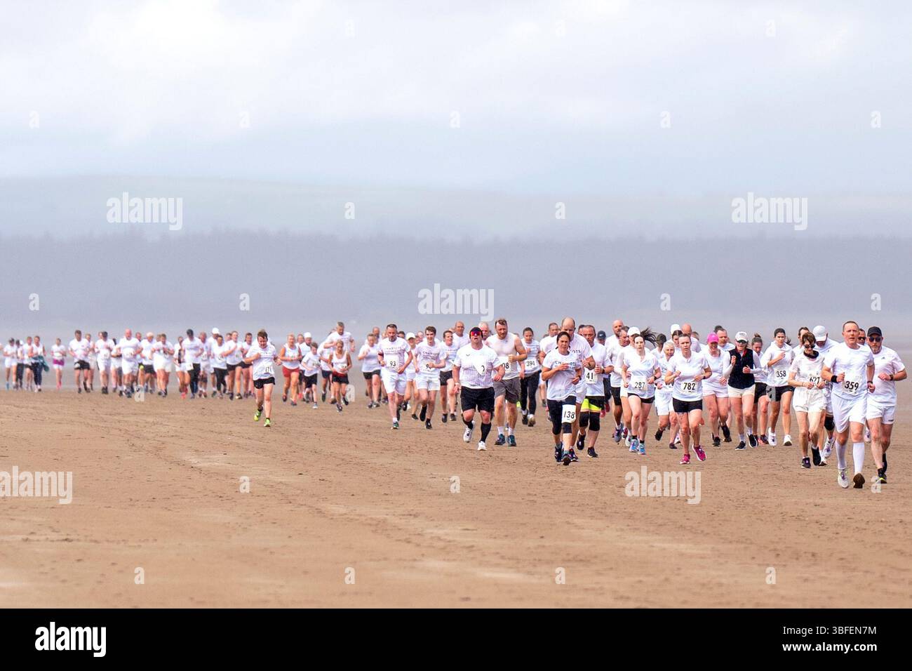 Runners, wearing white, compete in the annual Chariots of Fire race ...