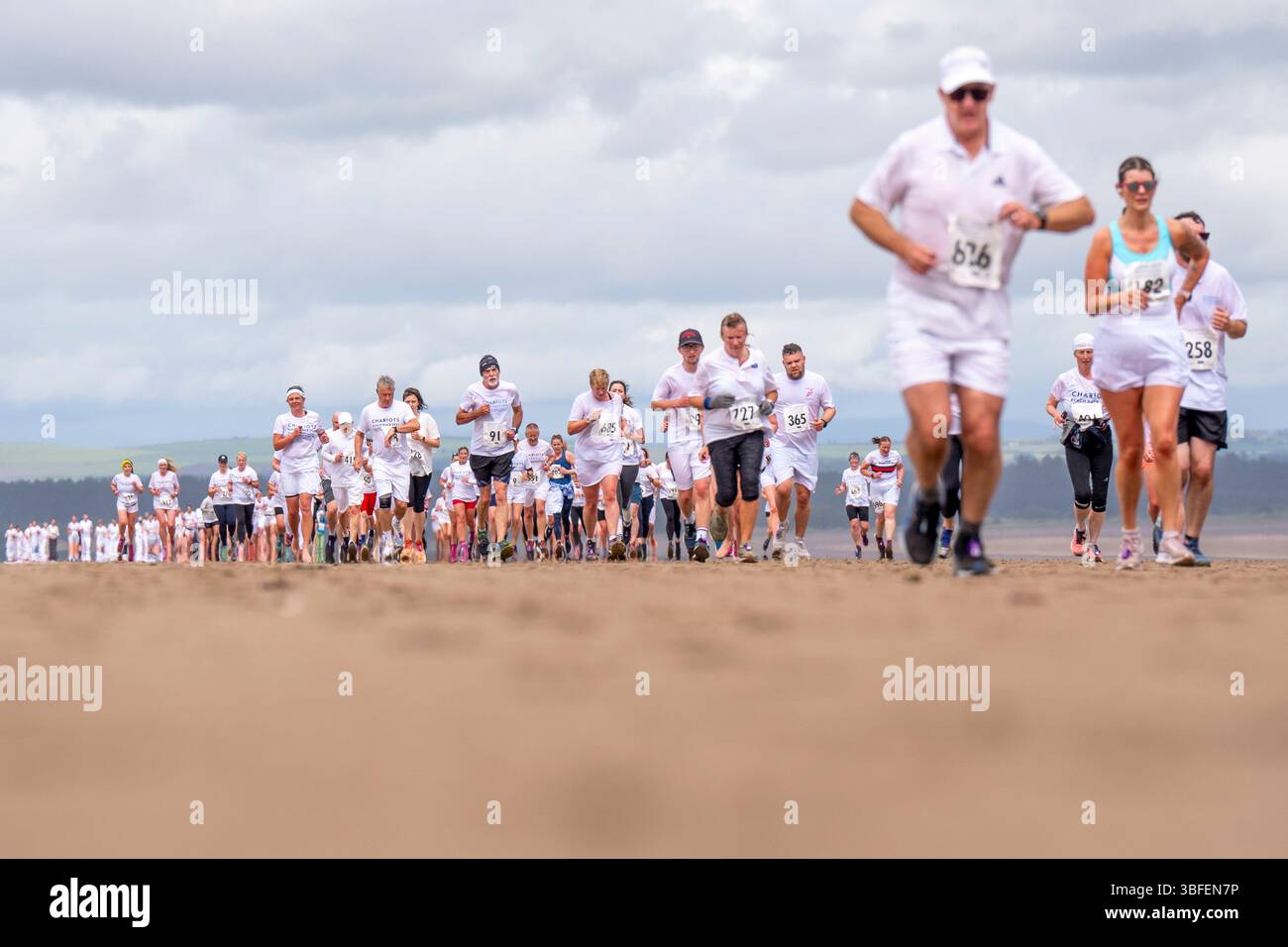 Runners, wearing white, compete in the annual Chariots of Fire race ...