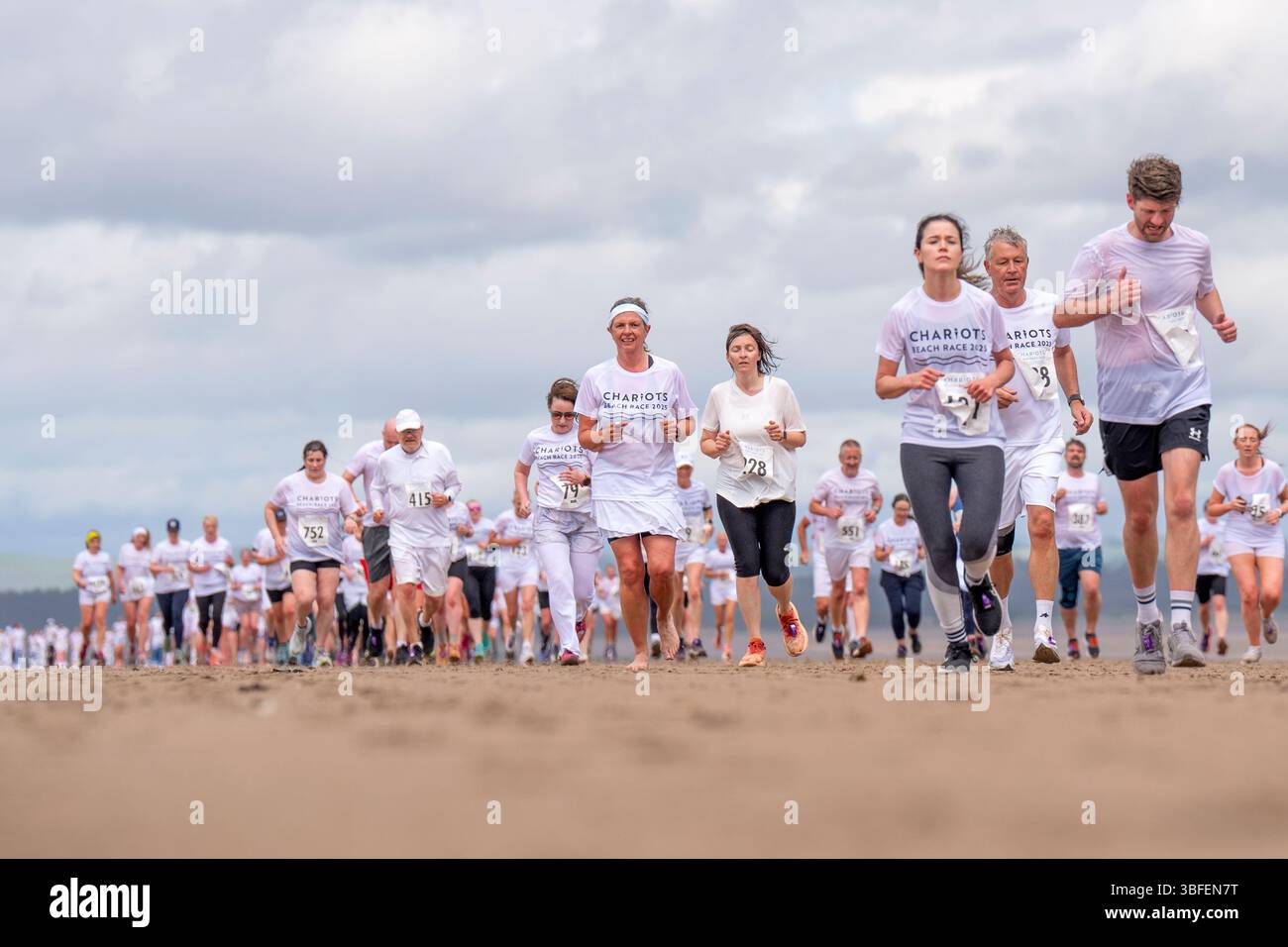Runners, wearing white, compete in the annual Chariots of Fire race ...