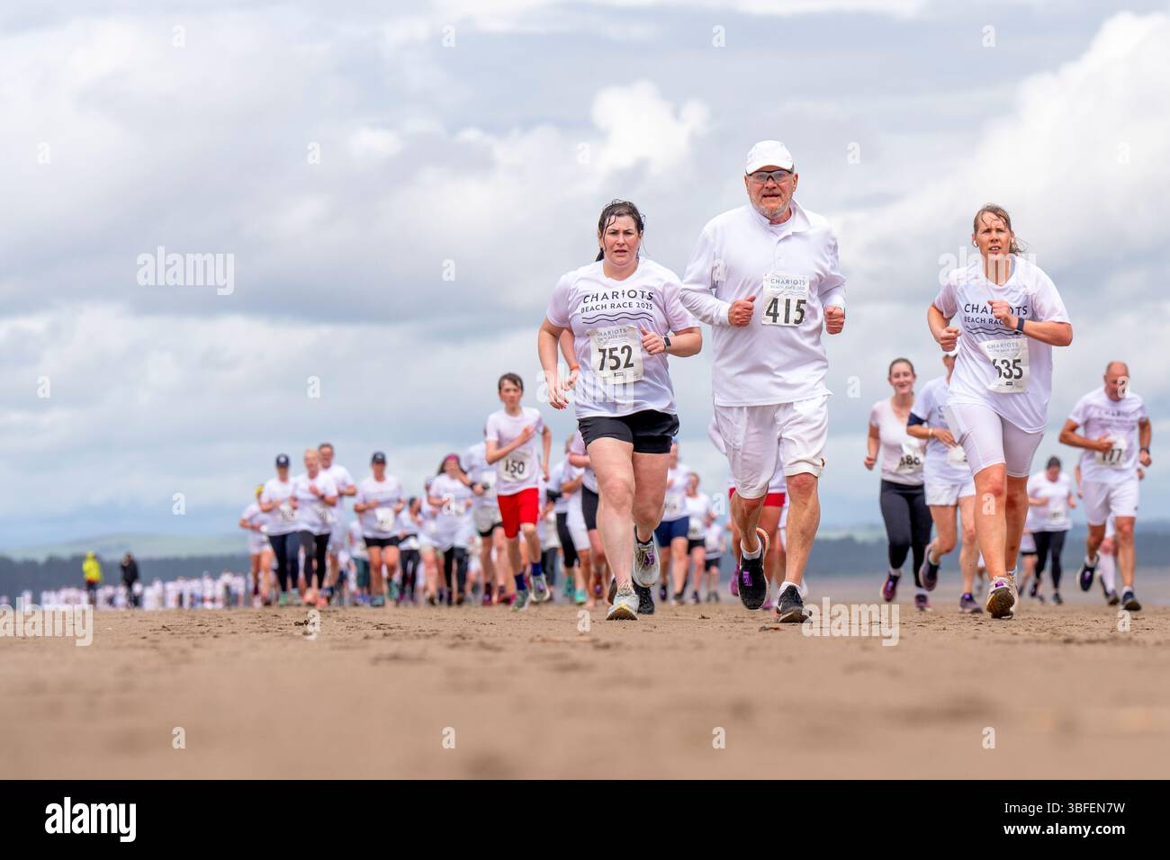 Runners, wearing white, compete in the annual Chariots of Fire race ...
