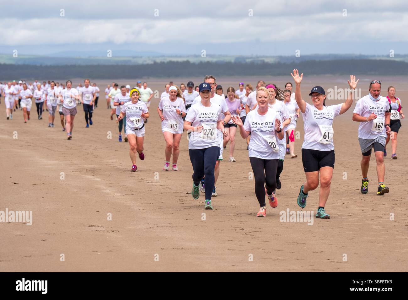 Runners, wearing white, compete in the annual Chariots of Fire race ...