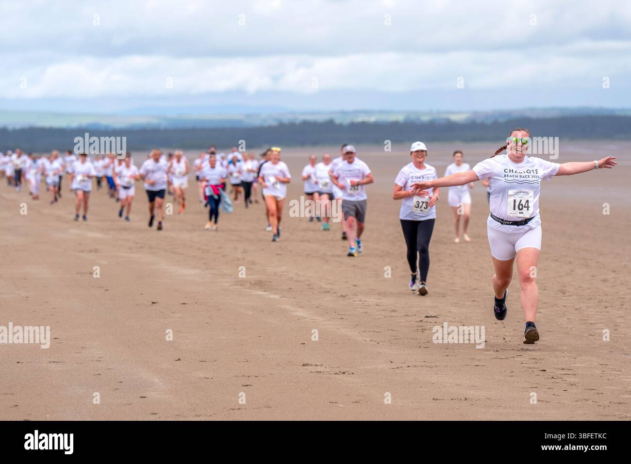 Runners, wearing white, compete in the annual Chariots of Fire race ...