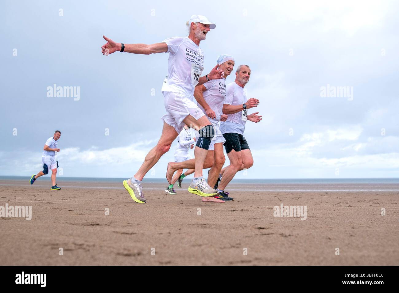 Runners, wearing white, compete in the annual Chariots of Fire race ...