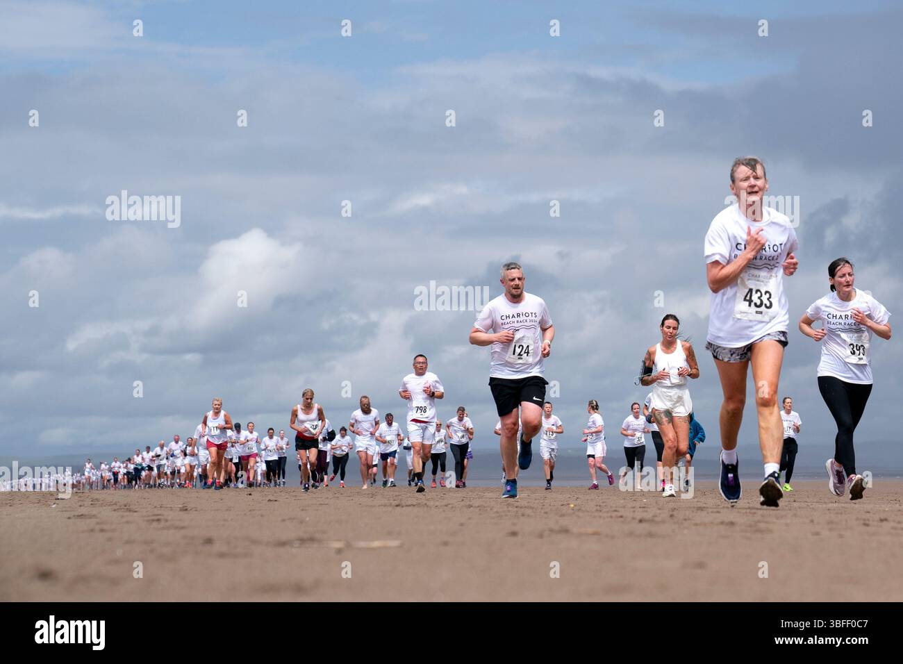 Runners, wearing white, compete in the annual Chariots of Fire race ...