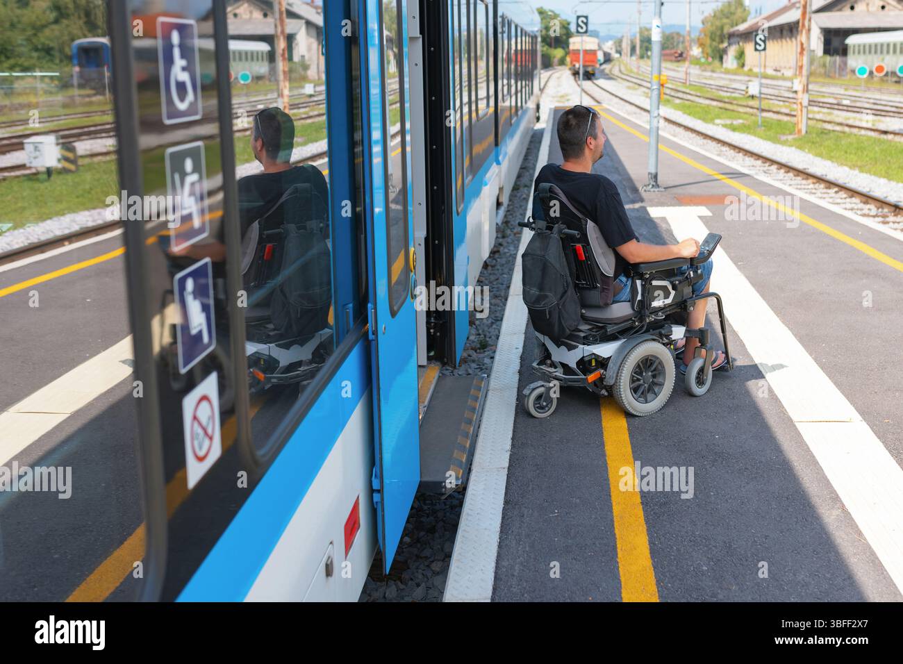 Wheelchair user using accessible train travel waits at a platform ...