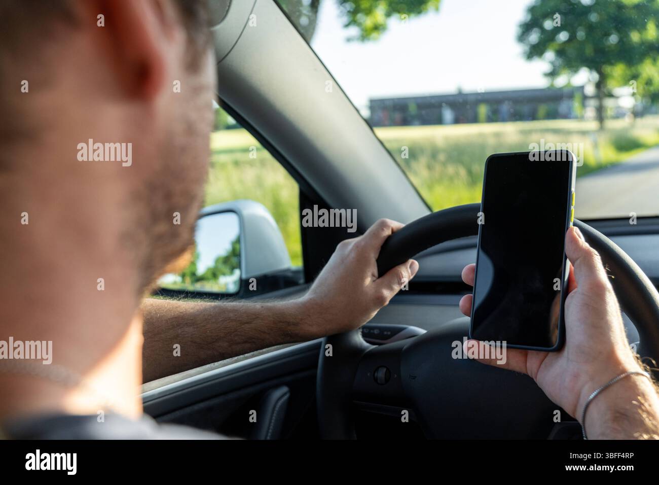 Bavaria, Germany - May 30, 2025: A man sits at the wheel of a moving ...