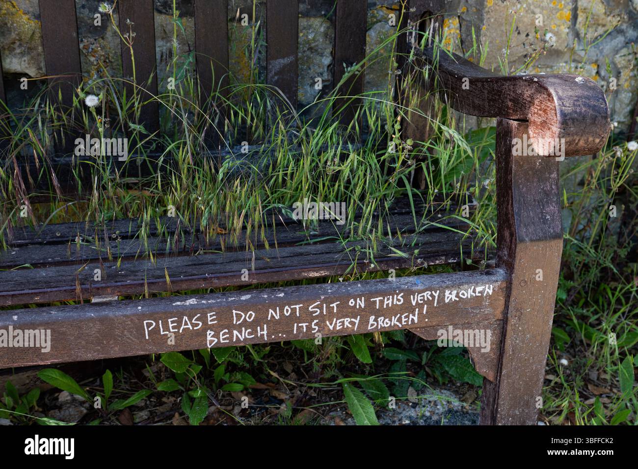 Broken Wooden Bench with Humorous Warning Sign Stock Photo - Alamy