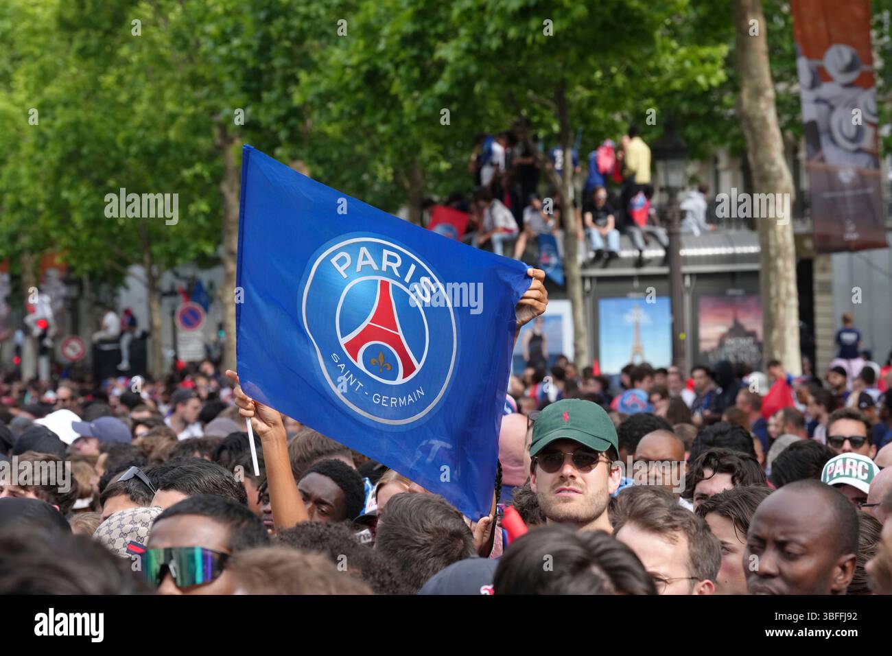 A supporter holds a PSG flag during a parade on the Champs-Elysee ...