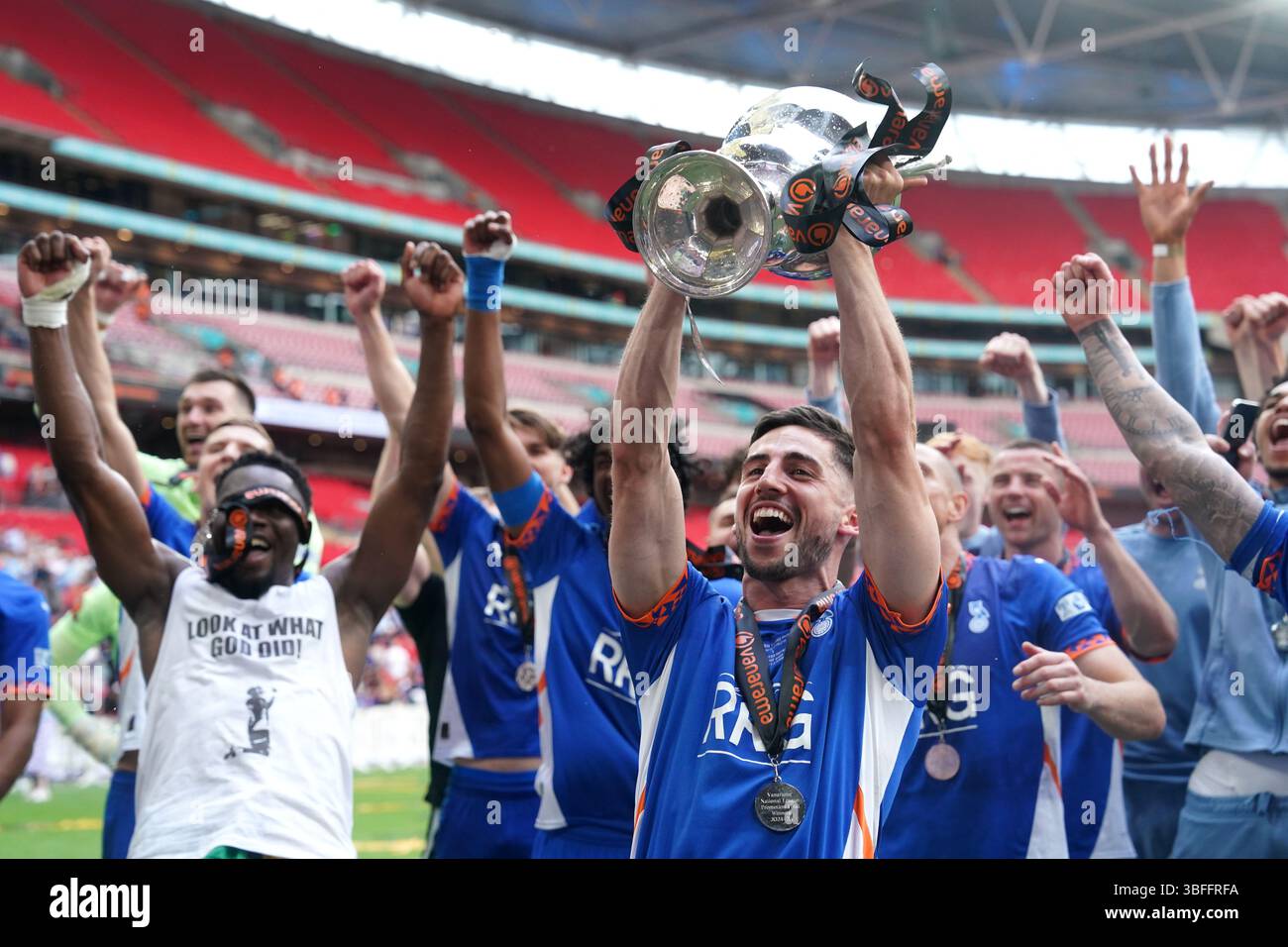 Oldham Athletic's Tom Pett lifts the trophy following the Vanarama ...