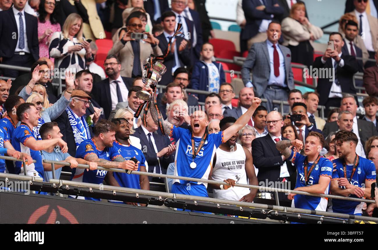 Oldham Athletic's Joe Garner lifts the trophy following the Vanarama ...