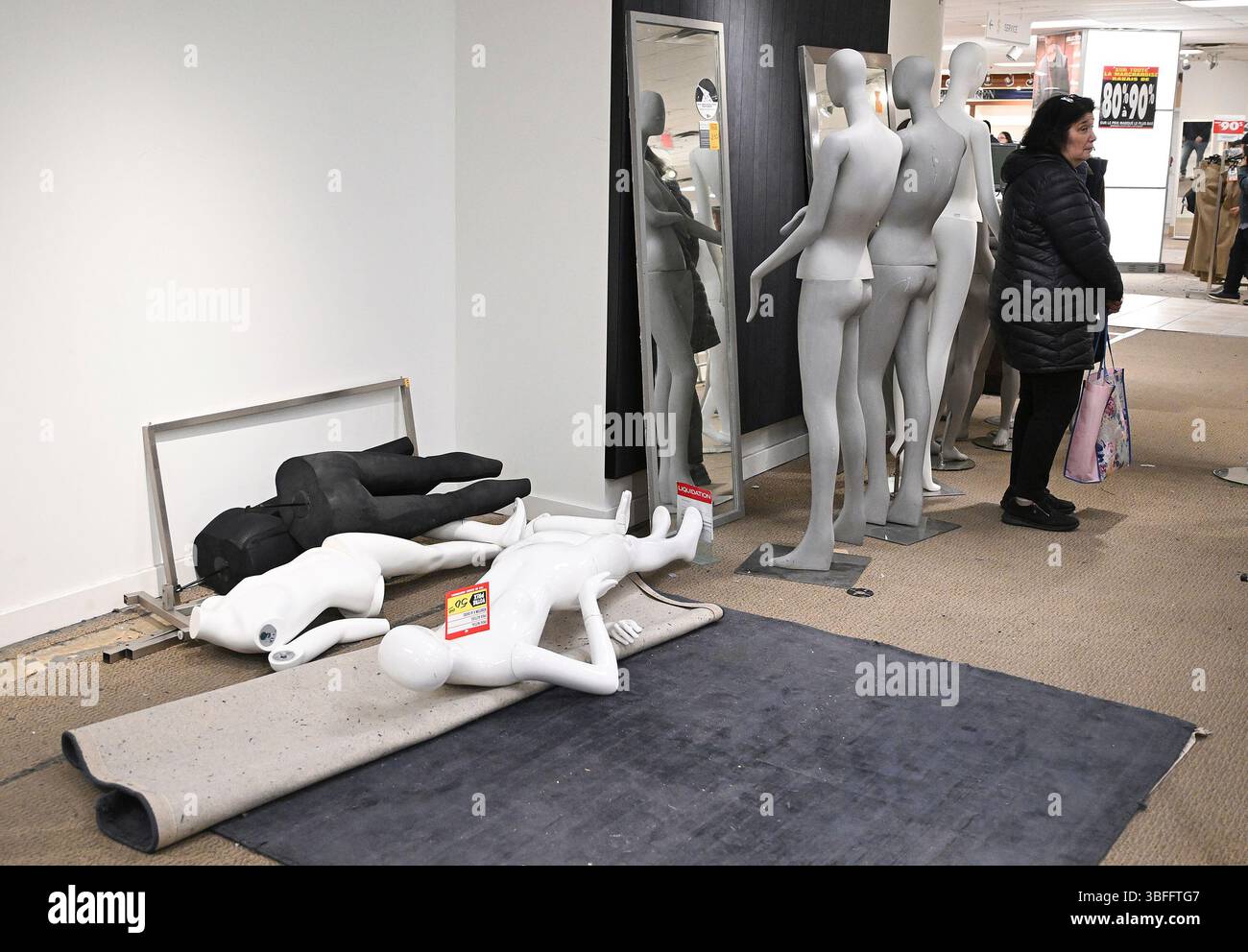 A woman stands next to mannequins at a Hudson's Bay store on the ...