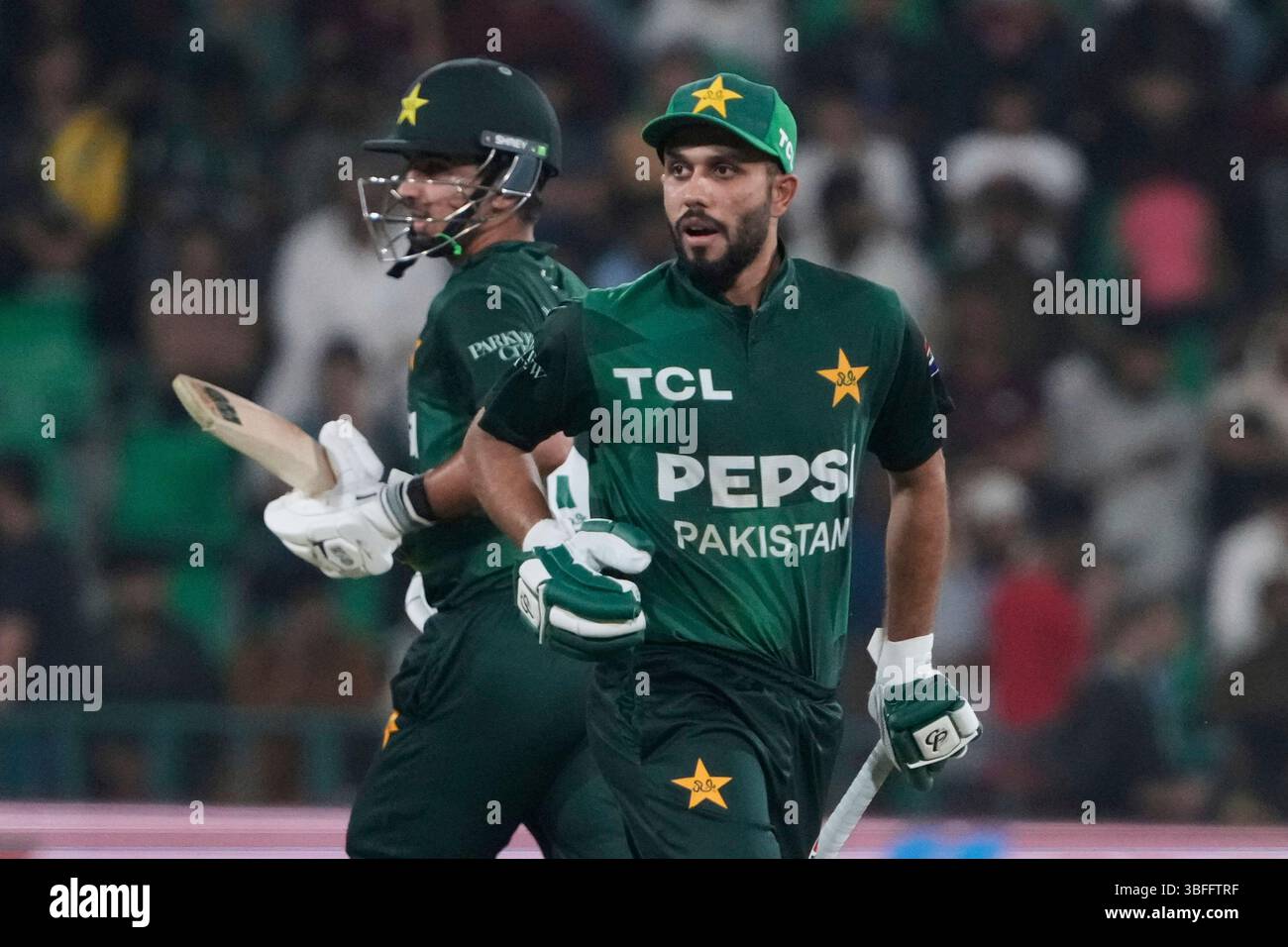 Pakistan's Mohammad Haris, right, and Saim Ayub run between the wickets ...
