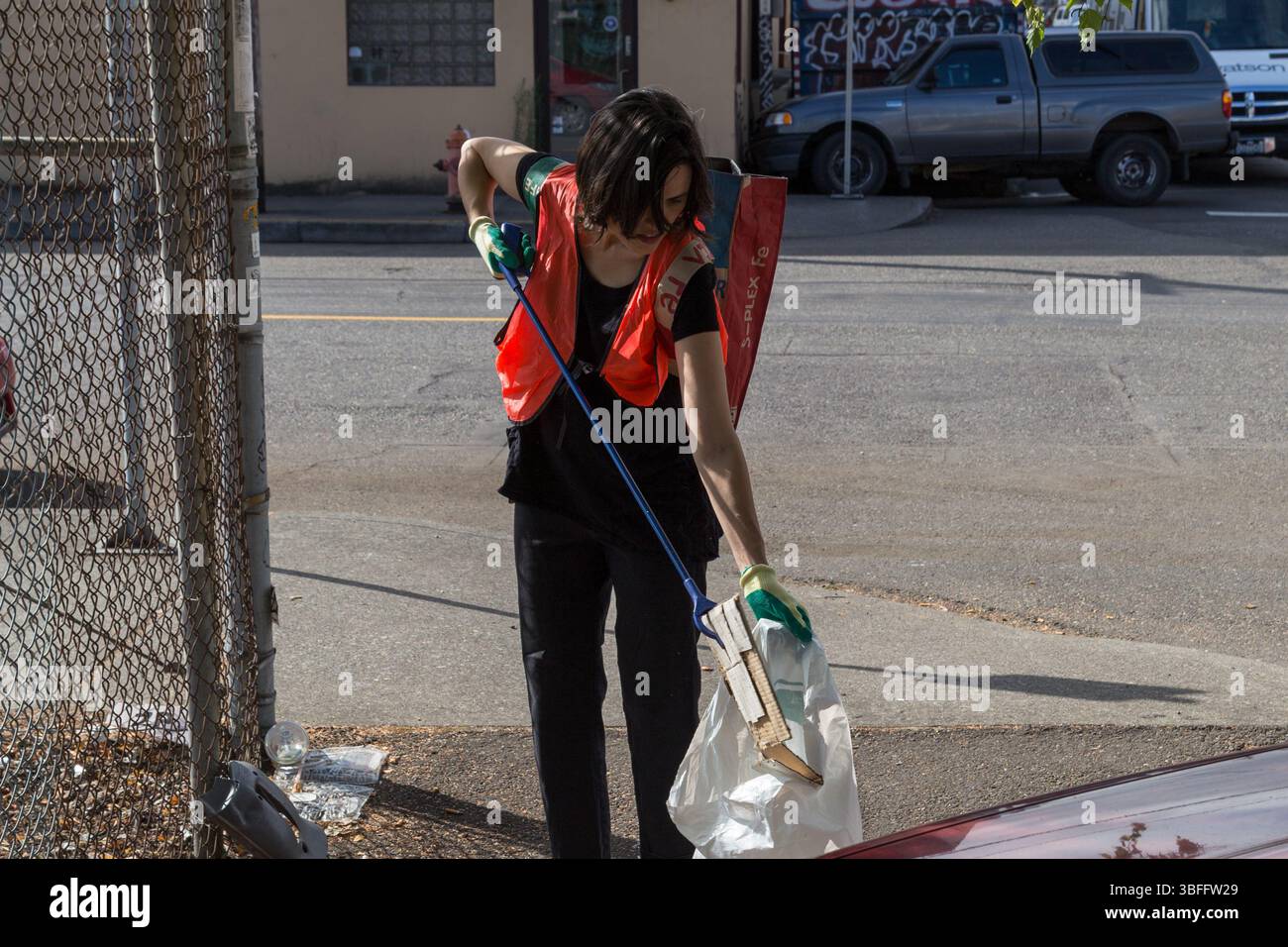 Portland, Oregon - August 17th 2017: A woman in a safety vest uses a ...