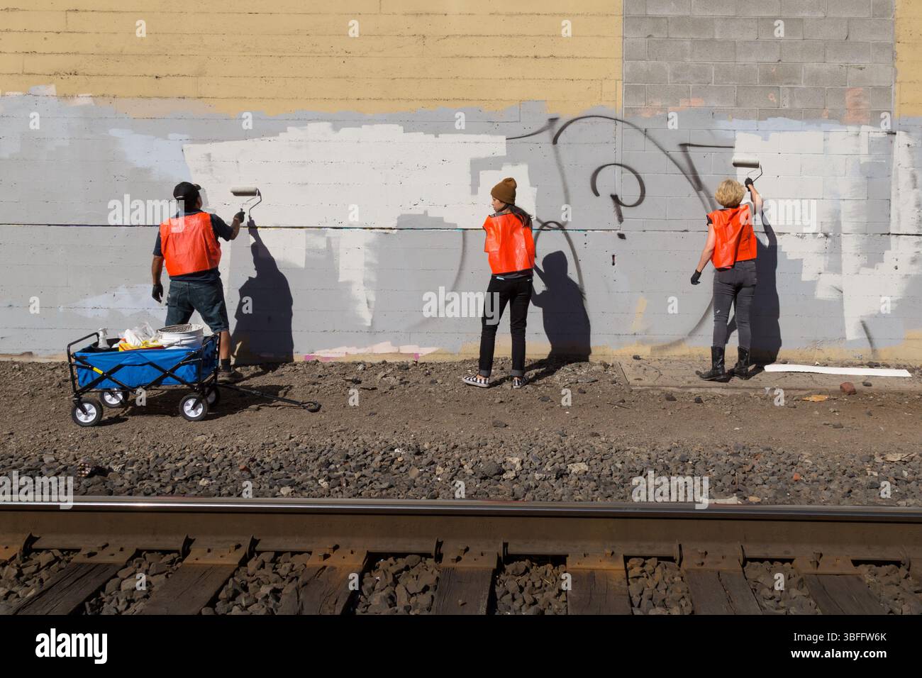 Volunteers painting over graffiti wall hi-res stock photography and ...