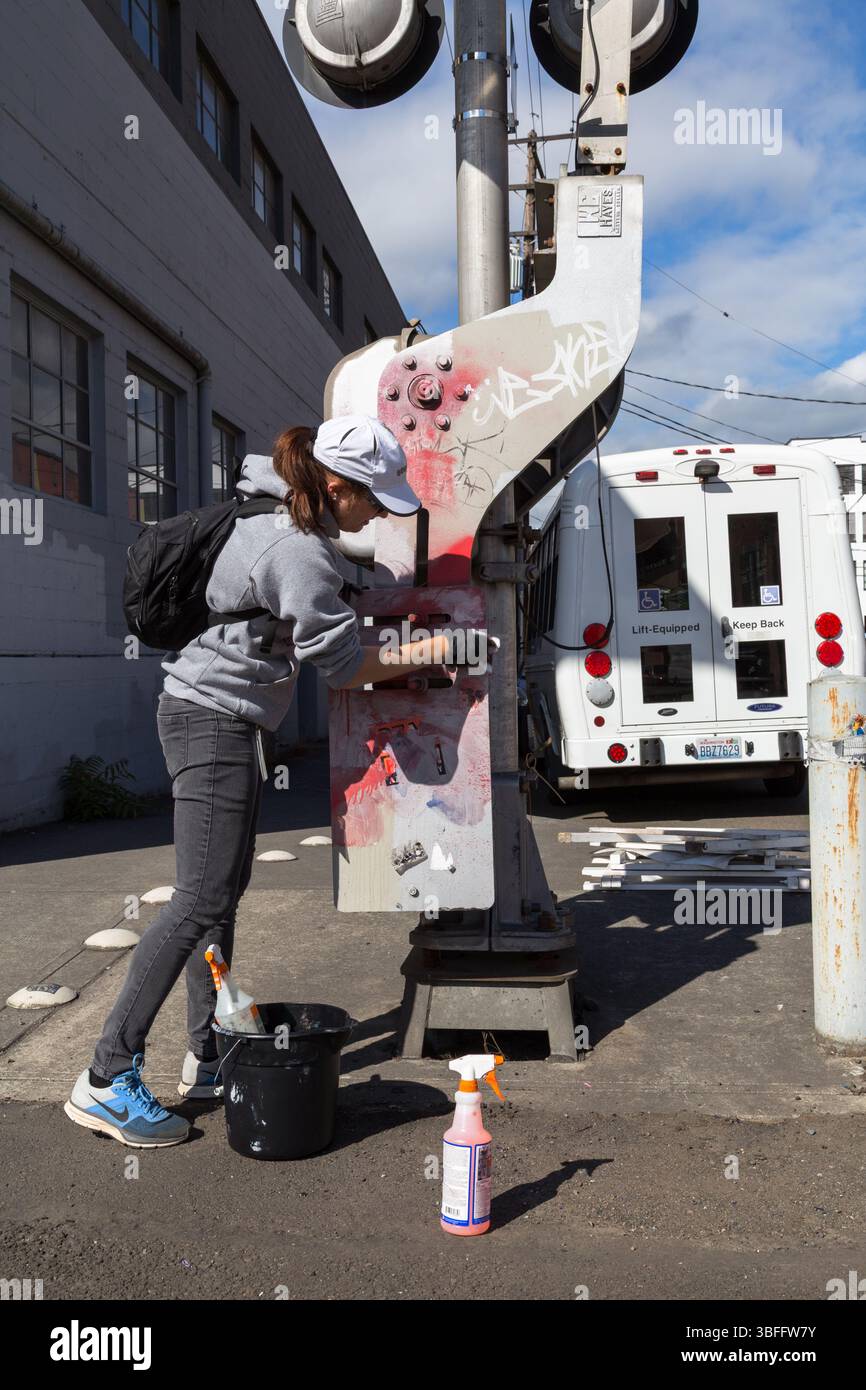 Portland, Oregon - August 17th 2017: A woman removes graffiti from a ...