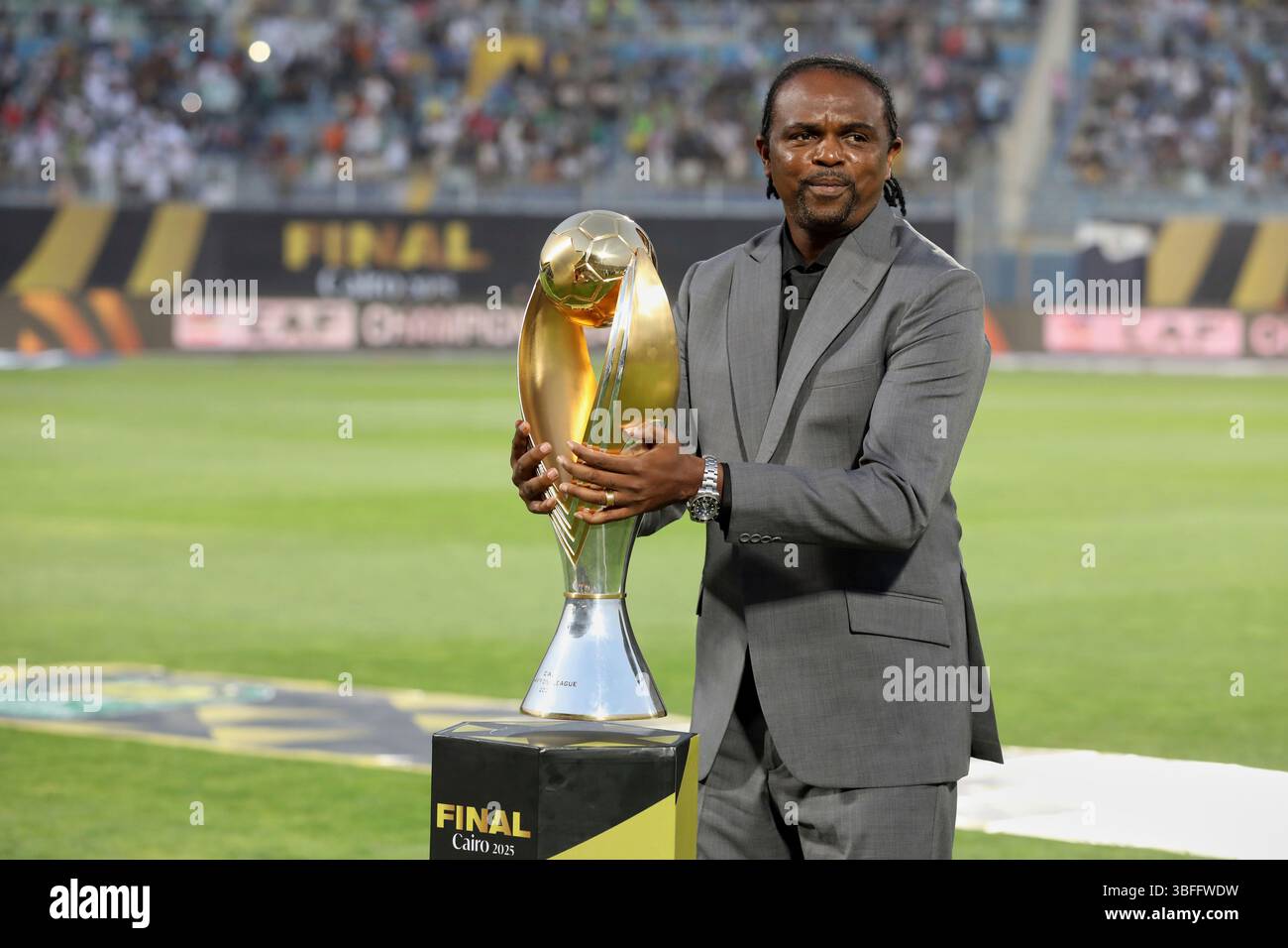Nigerian former player Nwankwo Kanu places the competition trophy on a ...